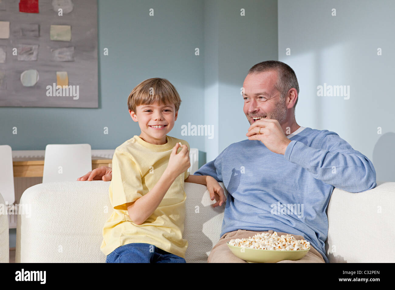 Father and son eating popcorn Stock Photo - Alamy