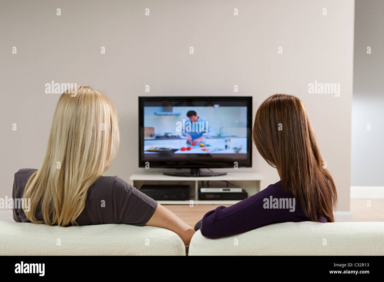 Two young women watching television Stock Photo - Alamy