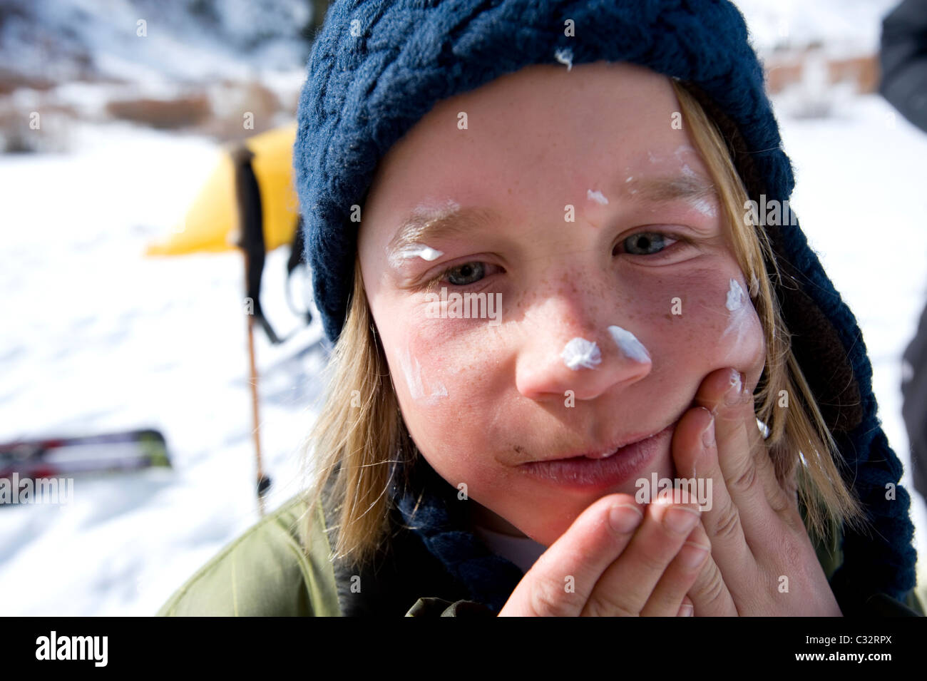 A boy applies sunscreen while camping in the backcountry of California ...