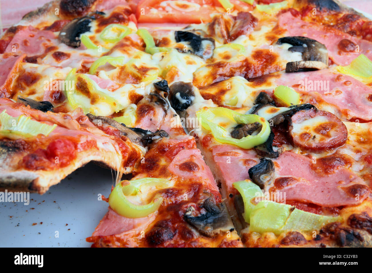 Thin crust Pizza cut in slices Stock Photo - Alamy