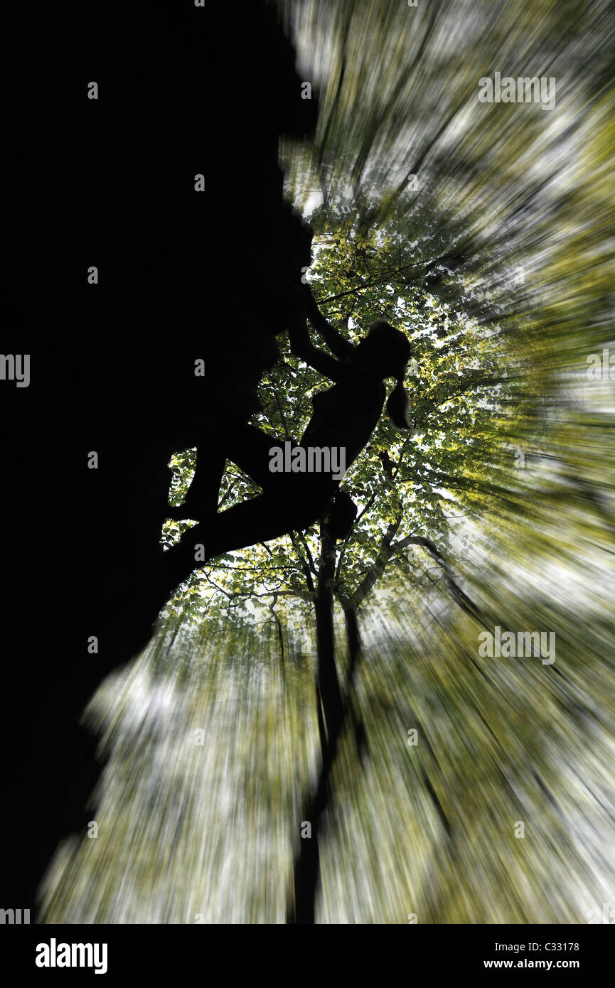 Silhouetted female rock climber climbing in sandstone cliff Wanterbaach ...