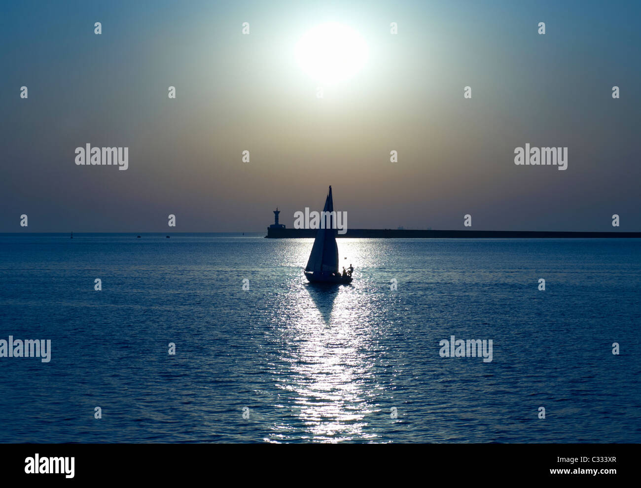 Sail boat against sunset Stock Photo - Alamy