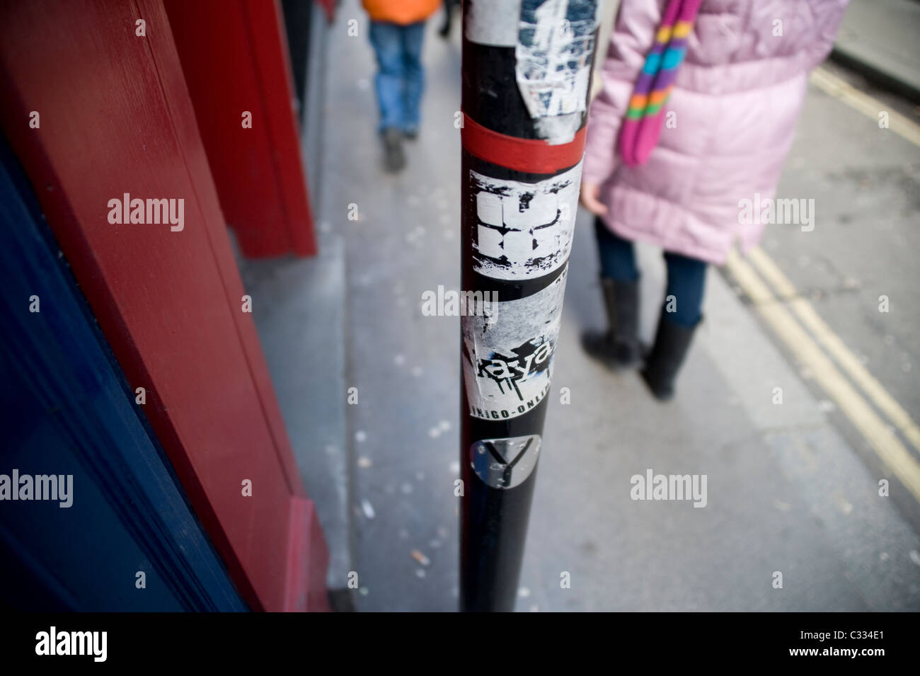 Double yellow line in street with pole and people Stock Photo - Alamy