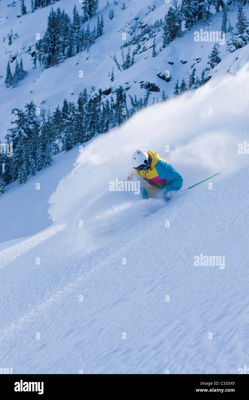 A man skiing powder snow at a ski resort in the Sierra mountains of ...