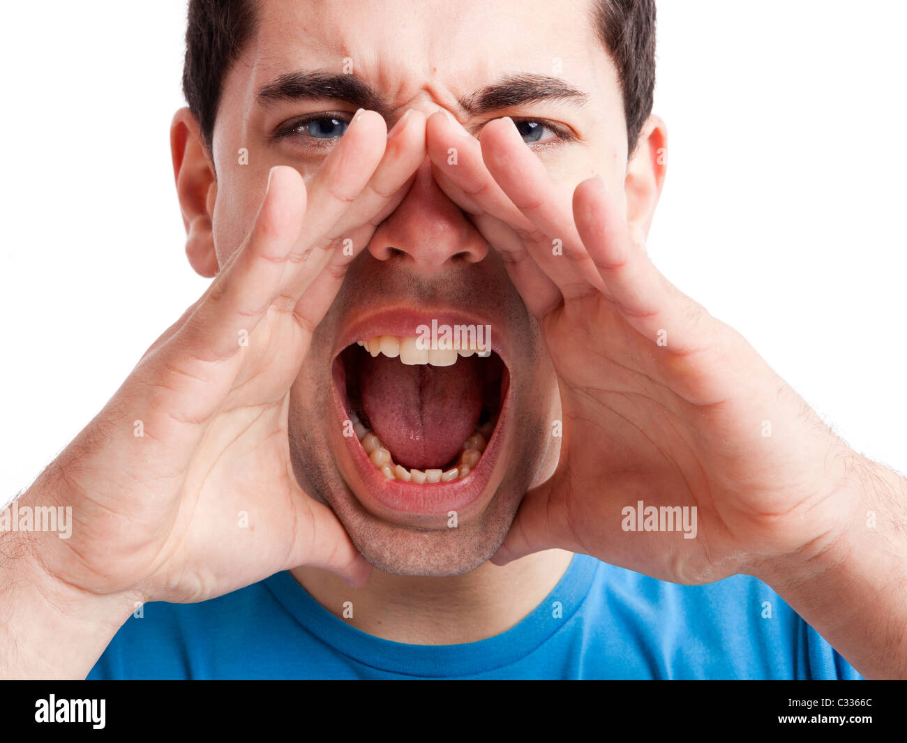 Portrait of a young man shouting loud with hands on the mouth, isolated ...