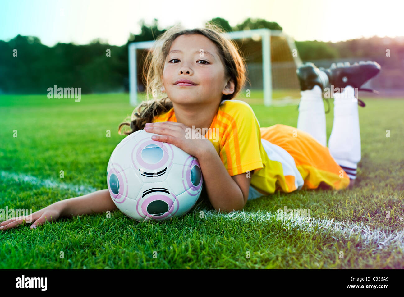 A young girl posing with her soccer ball on a soccer field in Los ...