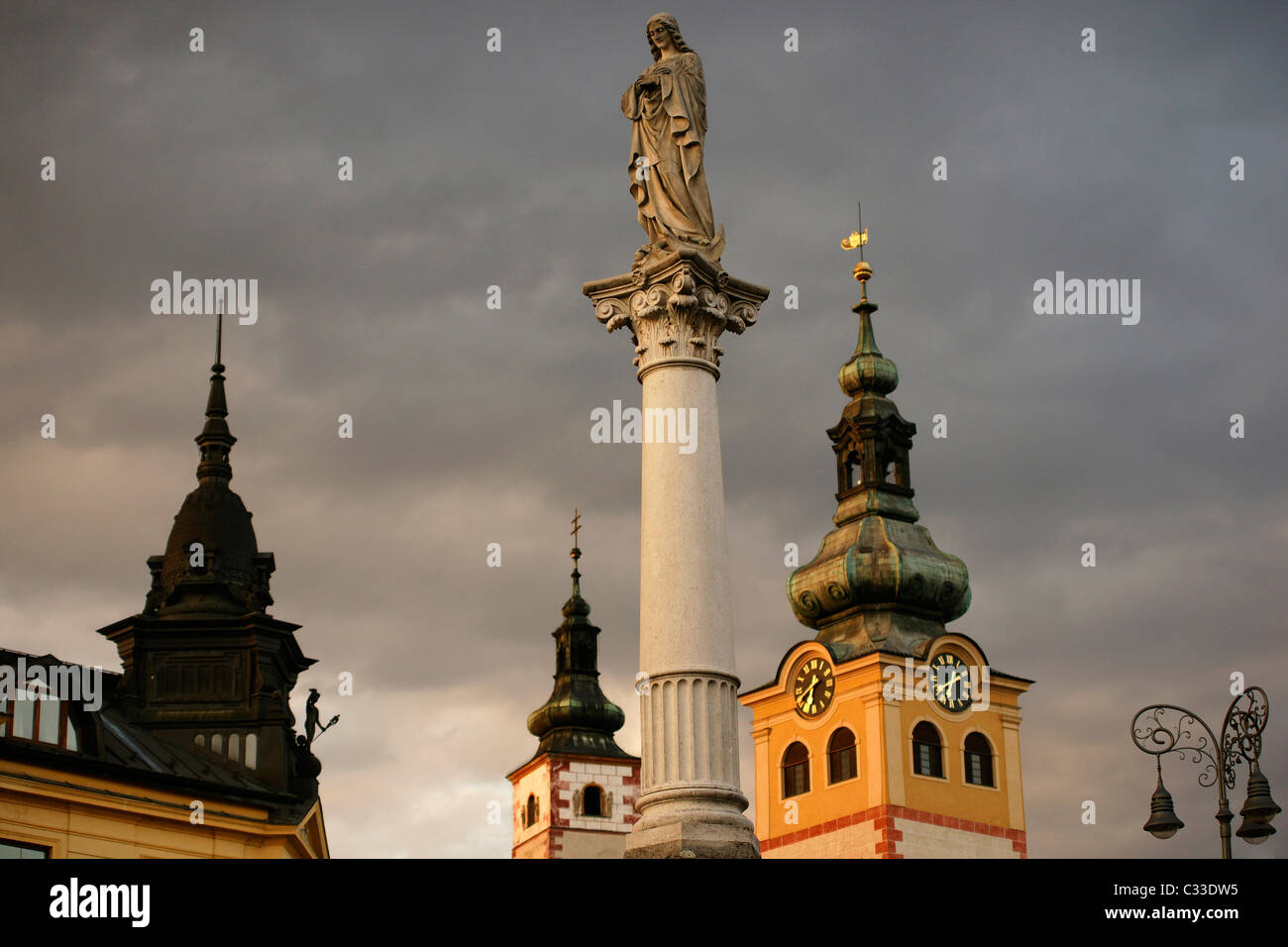 Tower spires and St Mary on column pillar against dark dramatic sky ...