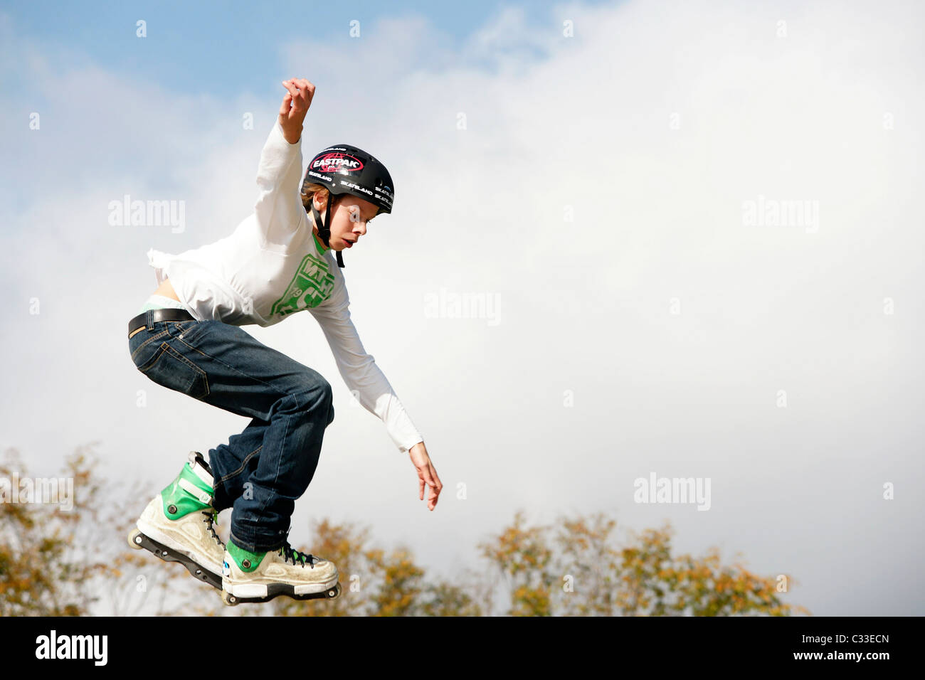 Urban sport stunt boy young man teen jumping against blue sky doing ...