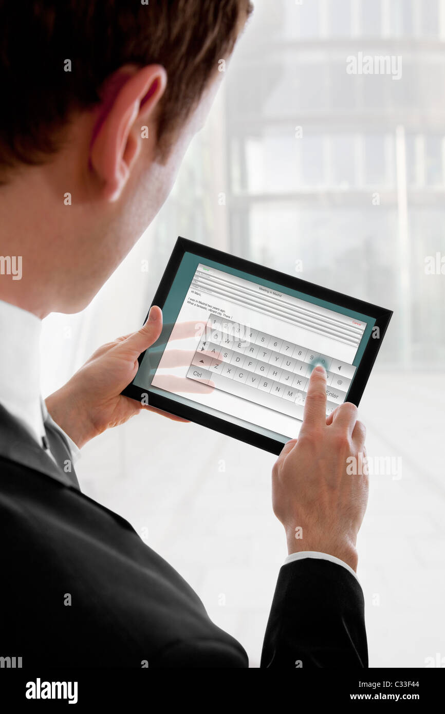Businessman holding a touchpad pc, one finger touches the screen and ...