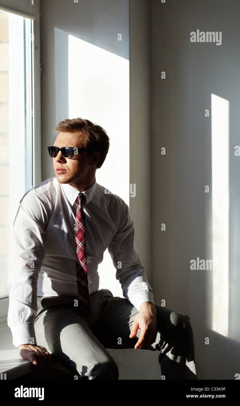Image of elegant man sitting by window Stock Photo - Alamy