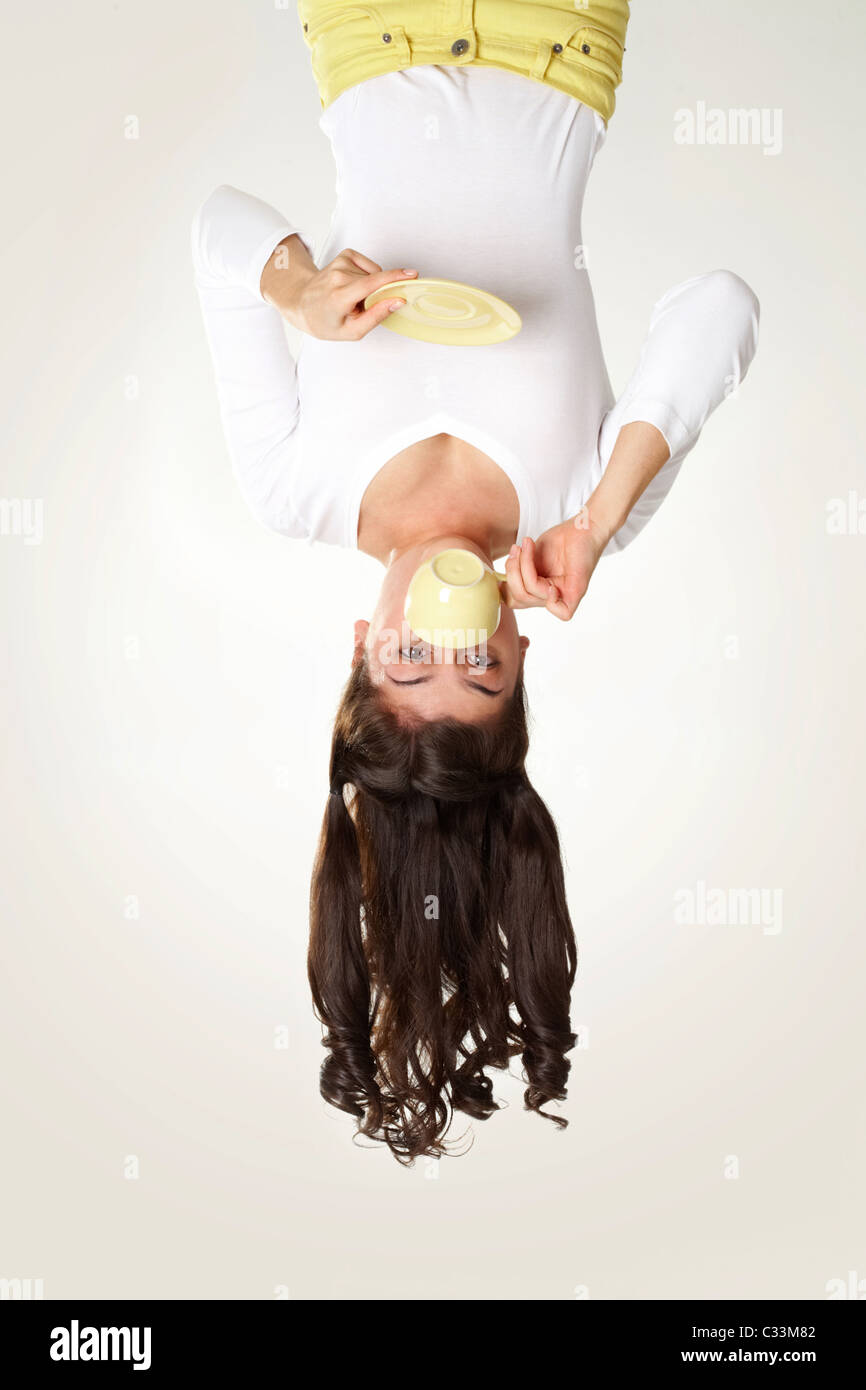 Upside down view of young girl drinking tea on white background Stock ...