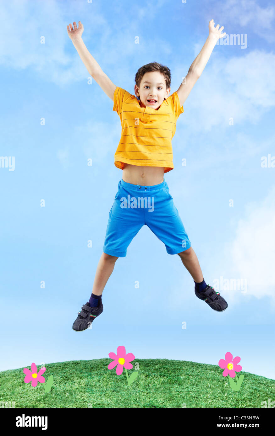 Image of happy boy jumping on the grass and looking at camera Stock ...