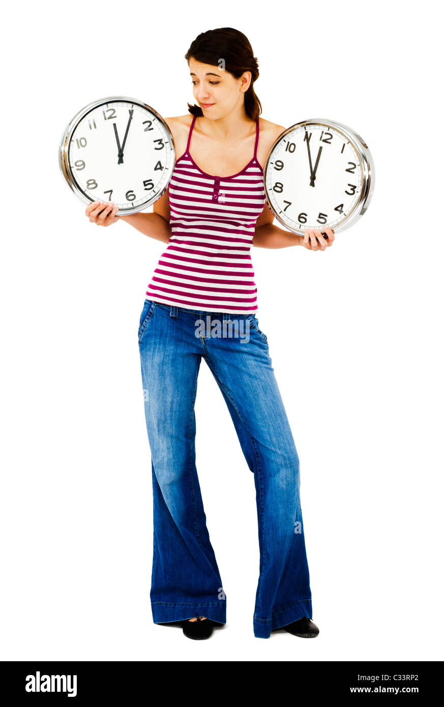 Standing woman holding clocks and posing isolated over white Stock ...