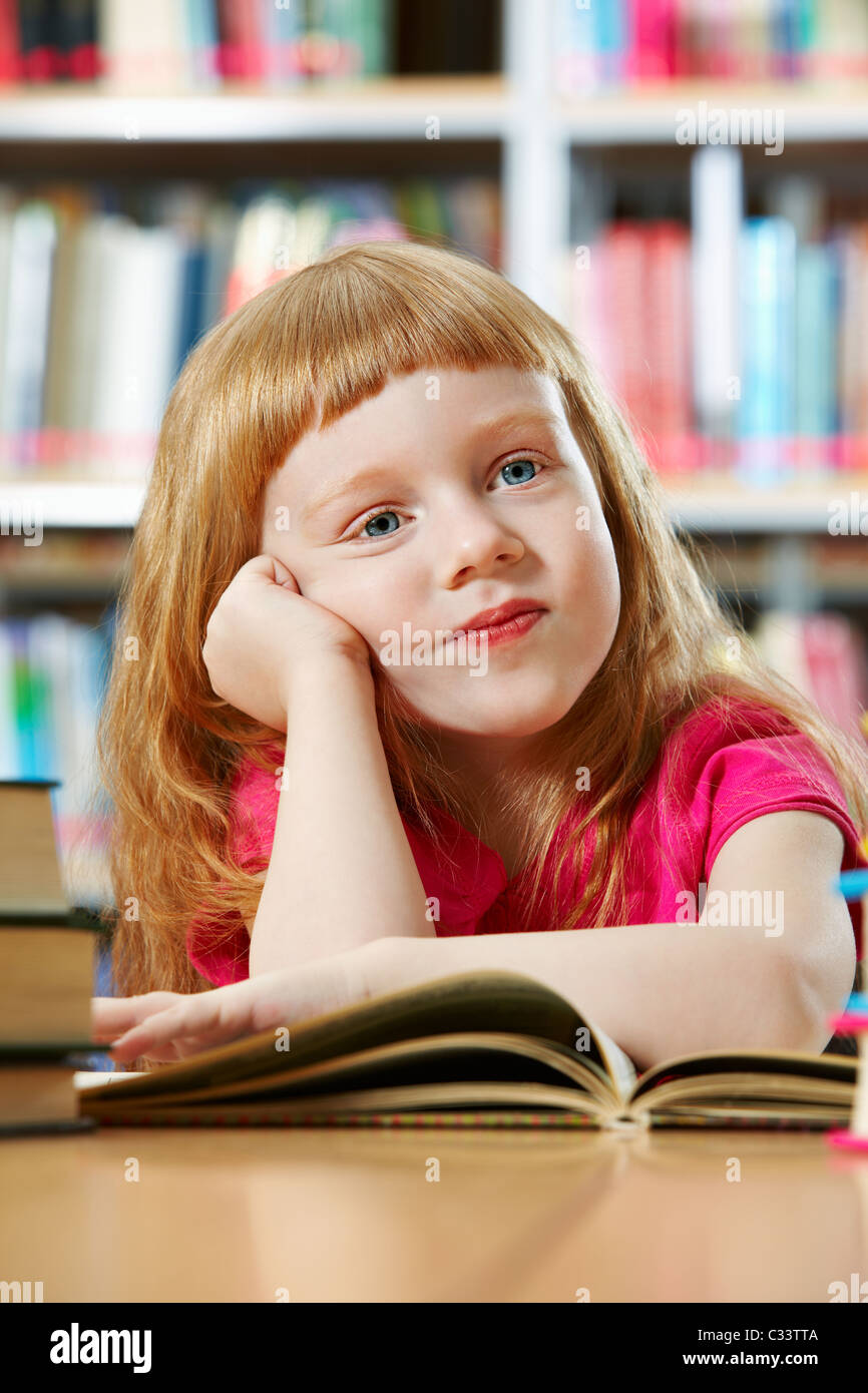 Portrait of smart girl with book in library Stock Photo - Alamy