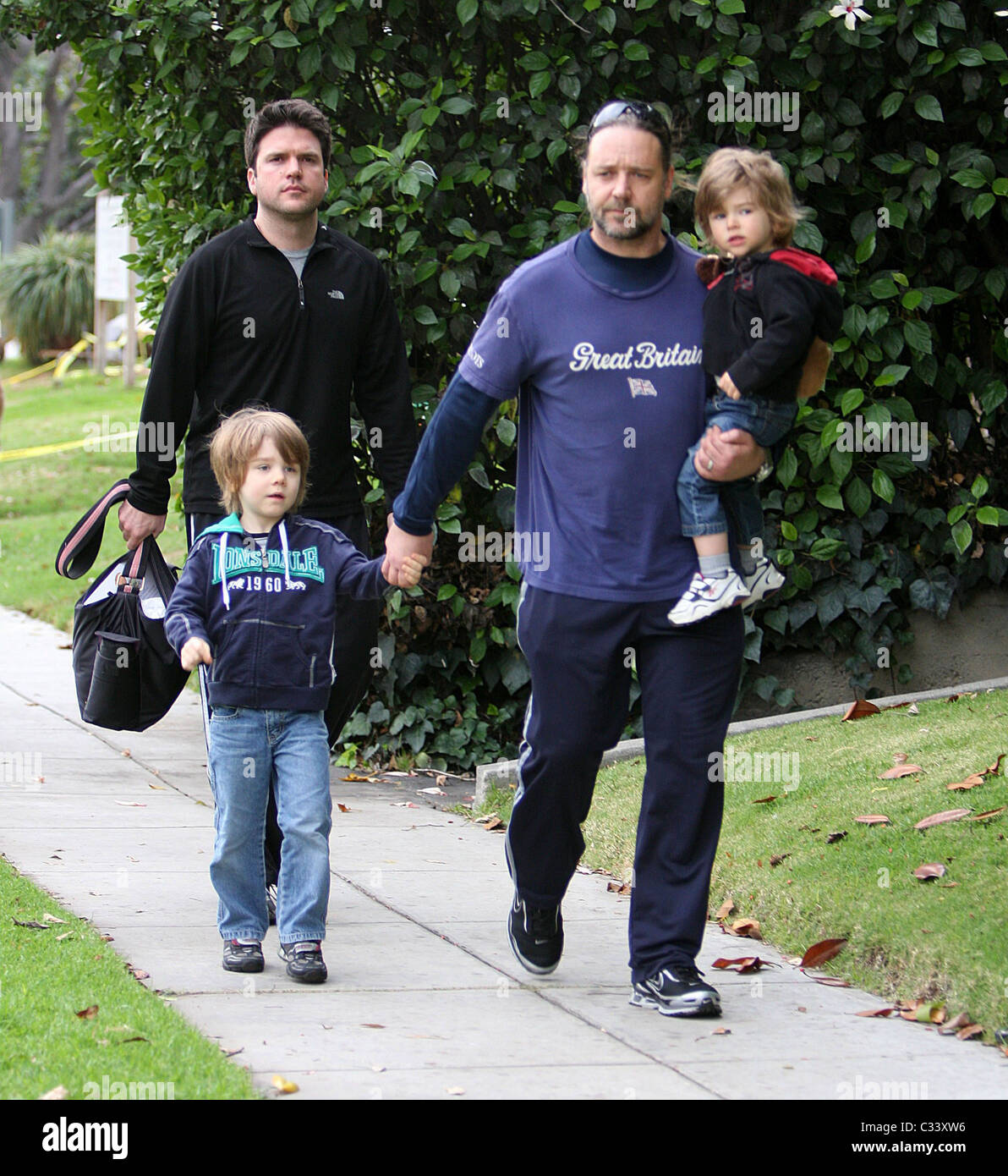 Russell Crowe, wearing a Great Britain t-shirt, holds the hand of his ...