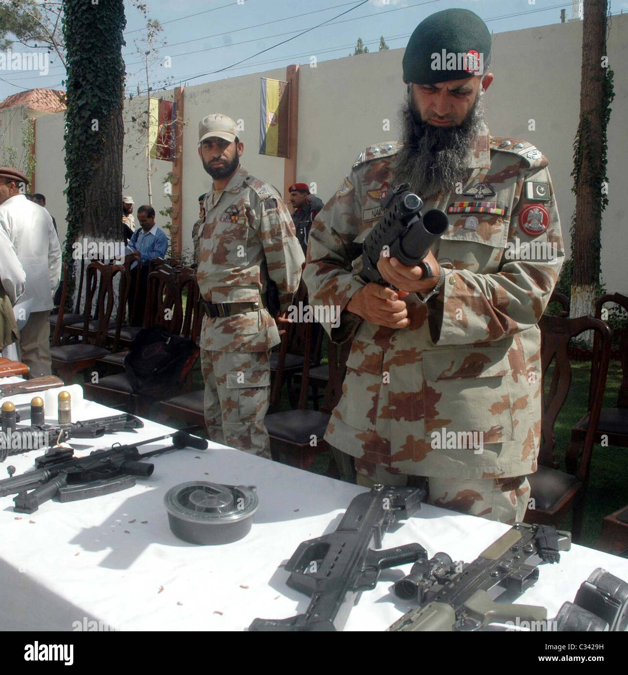 Frontier Corps official inspects seized arms which were recovered in a ...