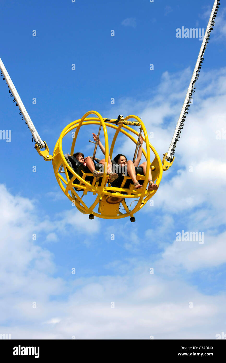 Two teenage girls riding a yellow Bungee Sphere Stock Photo - Alamy