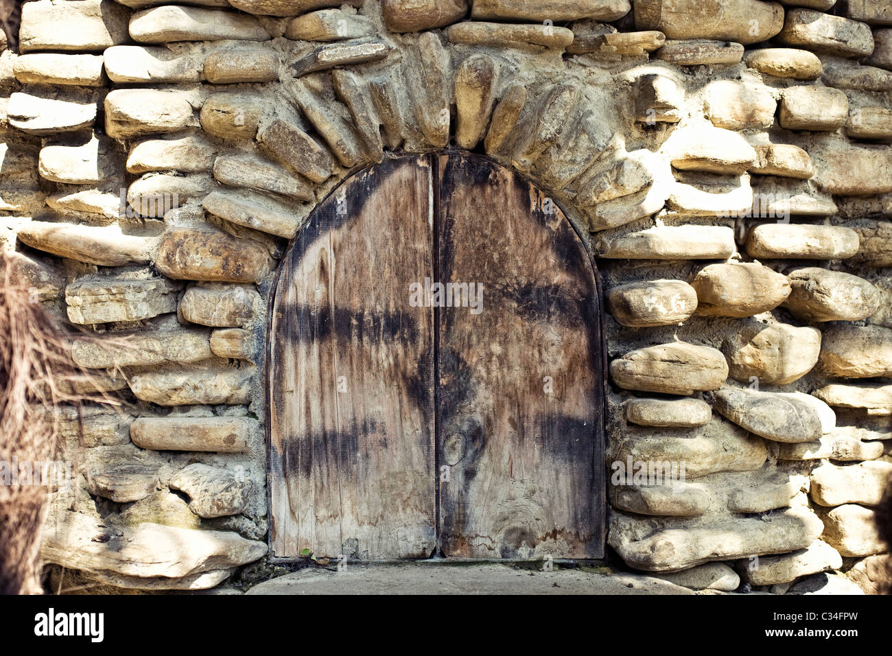 The old arched window in the stone wall with wooden shutters in the ...