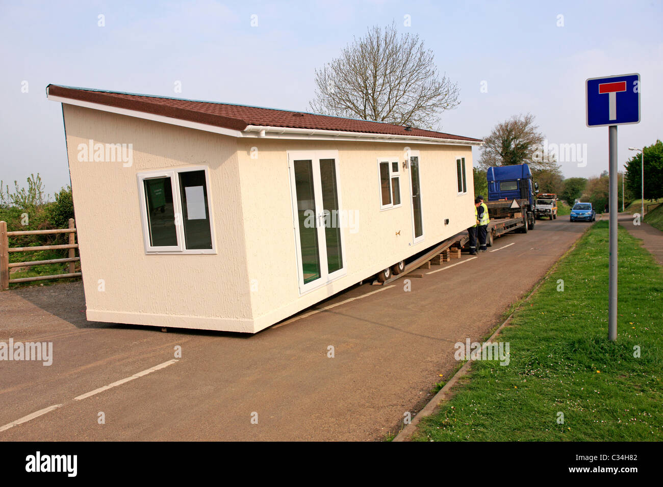 A Low-Loader truck carrying a mobile home starts to unload half of a ...