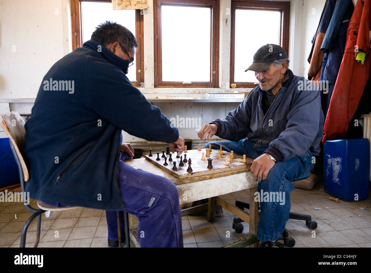 Fishermen playing "Checkers" board game. Also called "Draughts" board ...