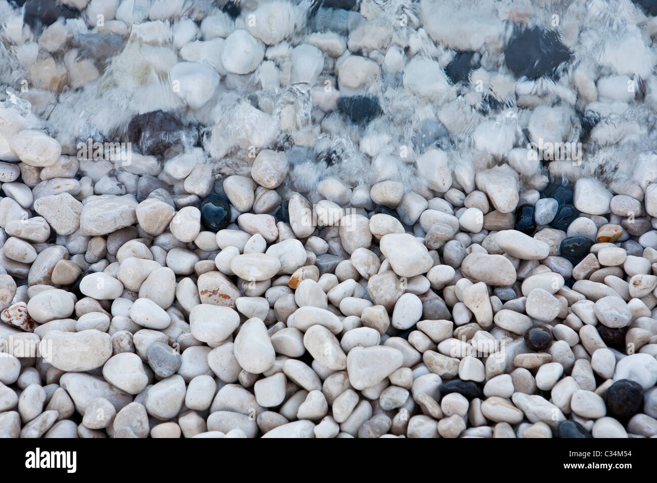 Tide rolling in over white pebbles on beach Stock Photo - Alamy