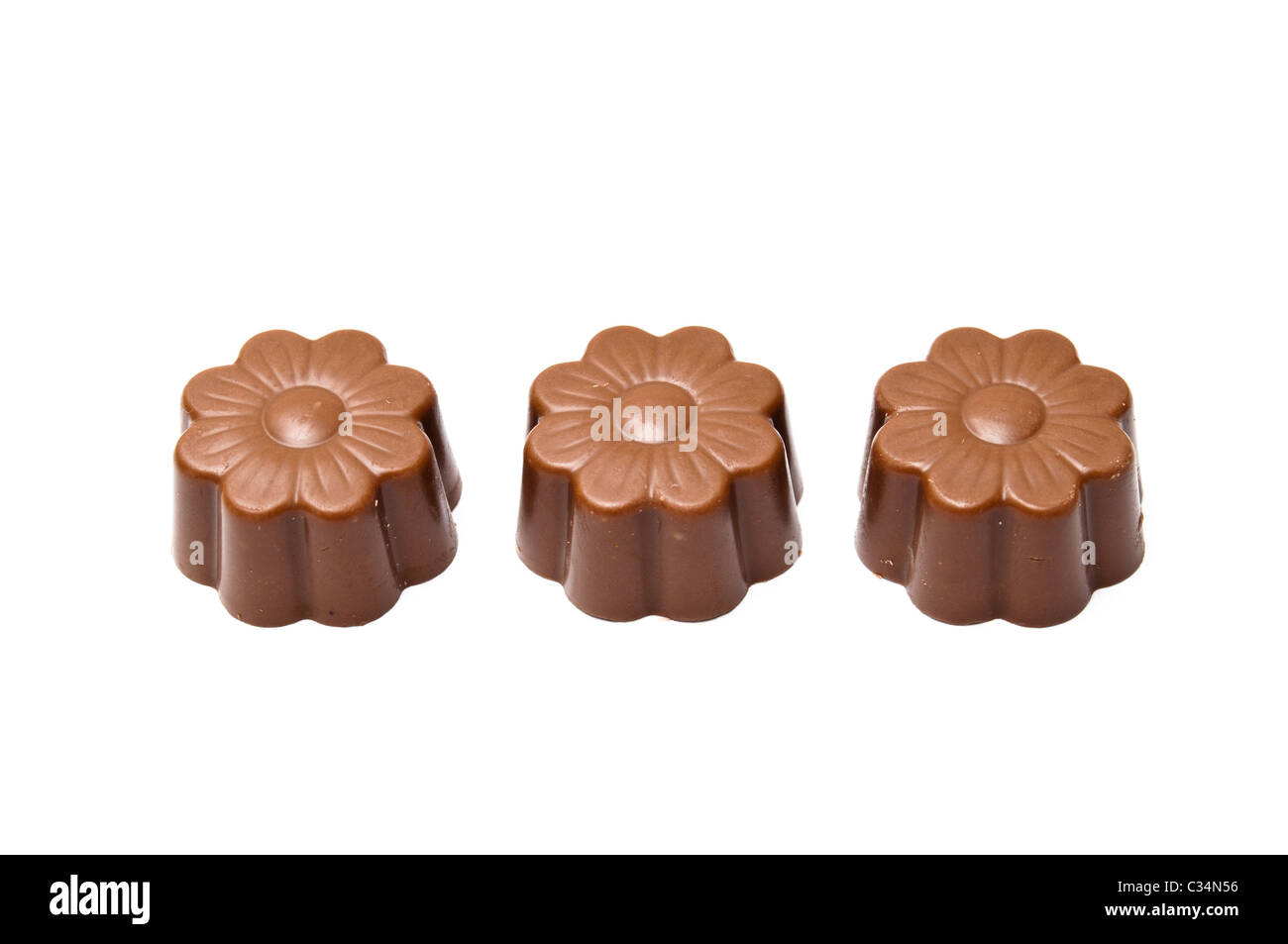 Three daisy shaped chocolate assortments isolated on white Stock Photo ...
