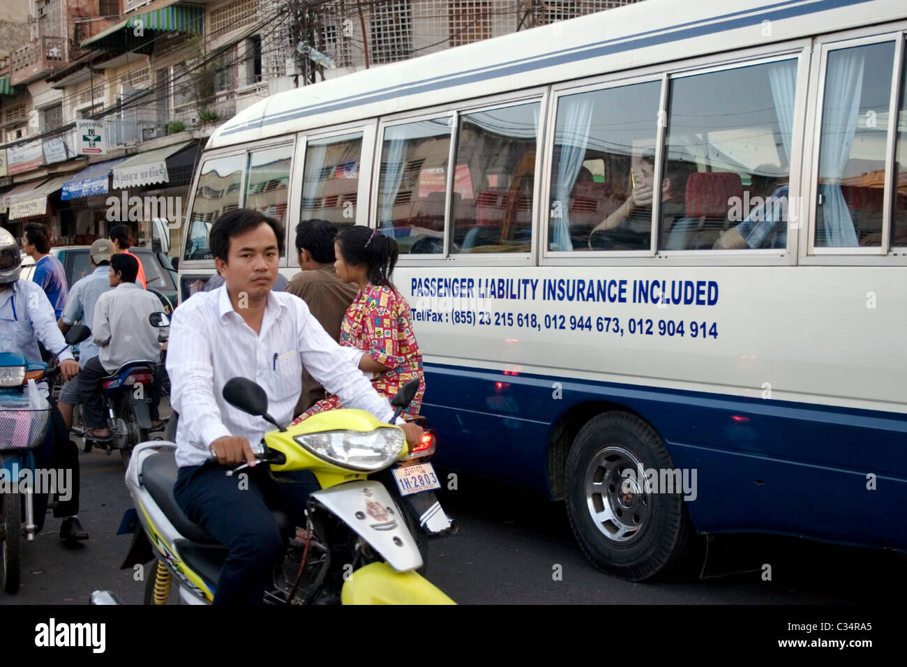 Foreign tourists are riding in a tour bus on a street crowded with ...