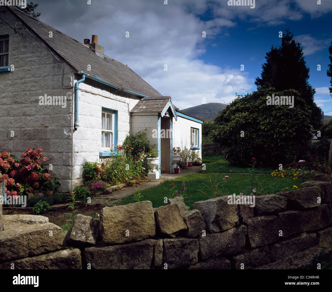 Exterior Of Quaint Country Cottage With Stone Wall In Foreground Stock ...