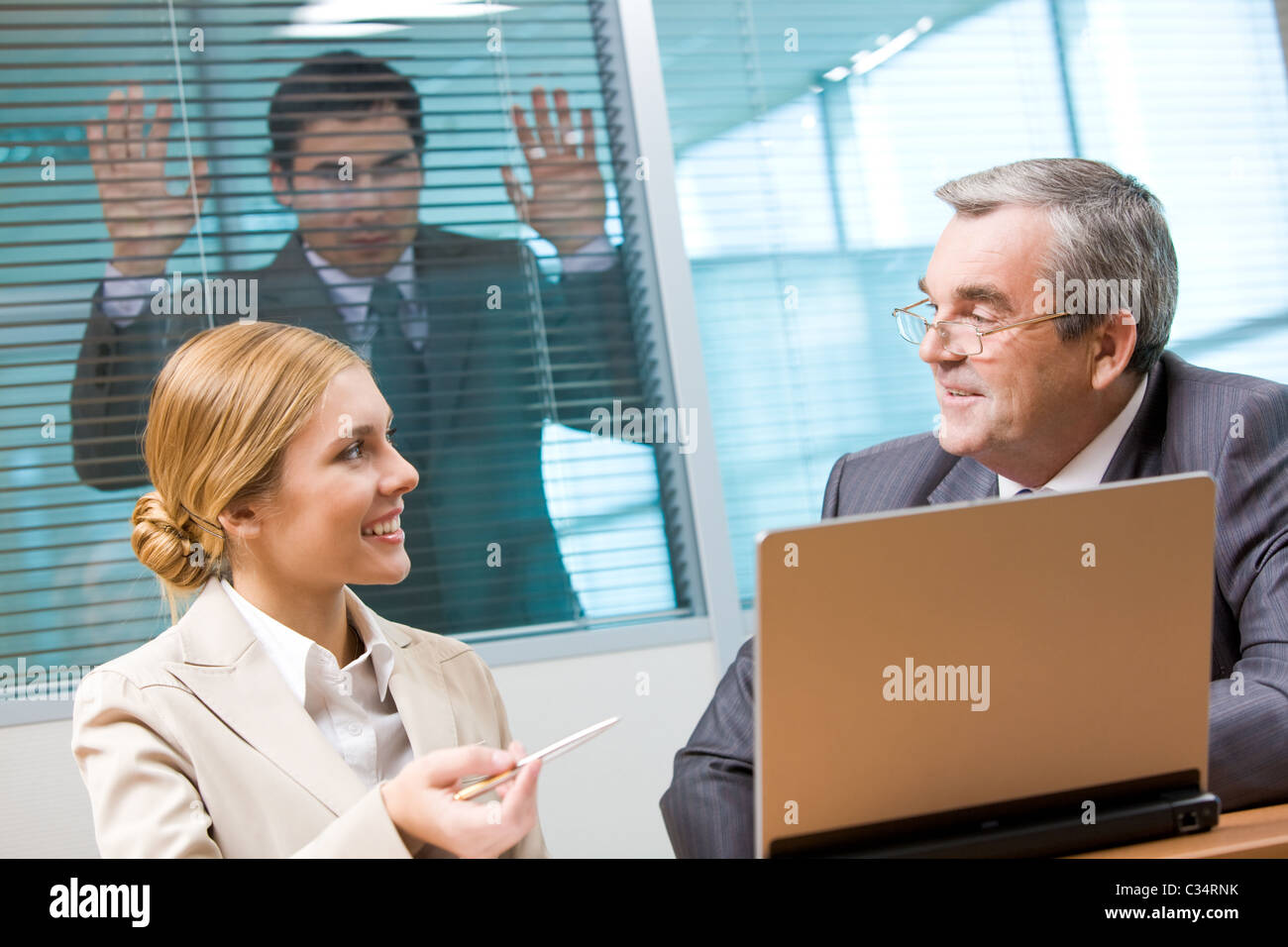 Portrait of executive employees looking at each other and communicating ...