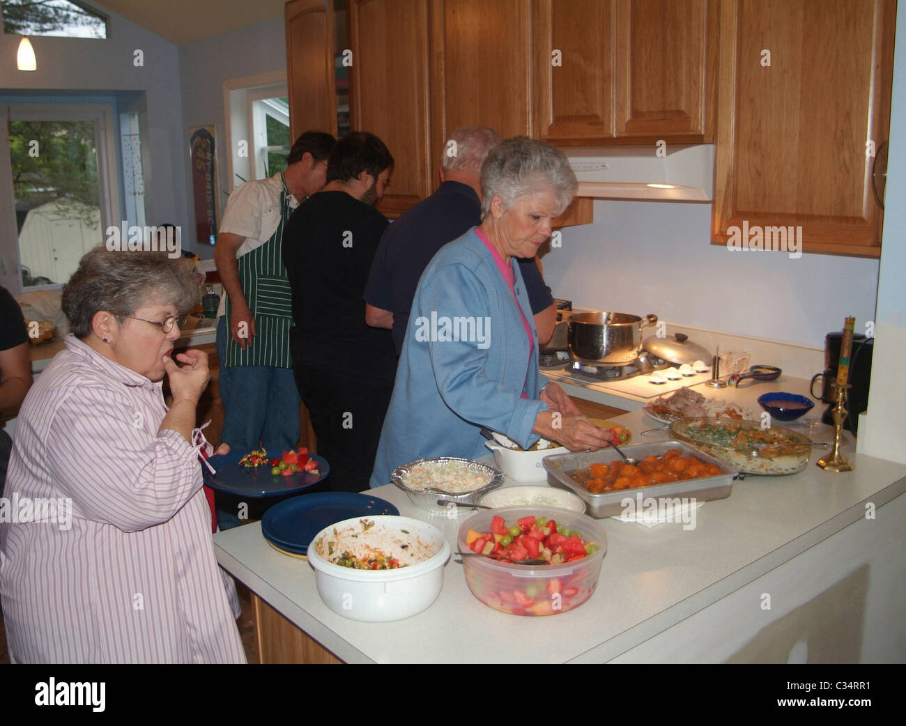 women fixing dinner and samples it while men prepare the turkey( in ...