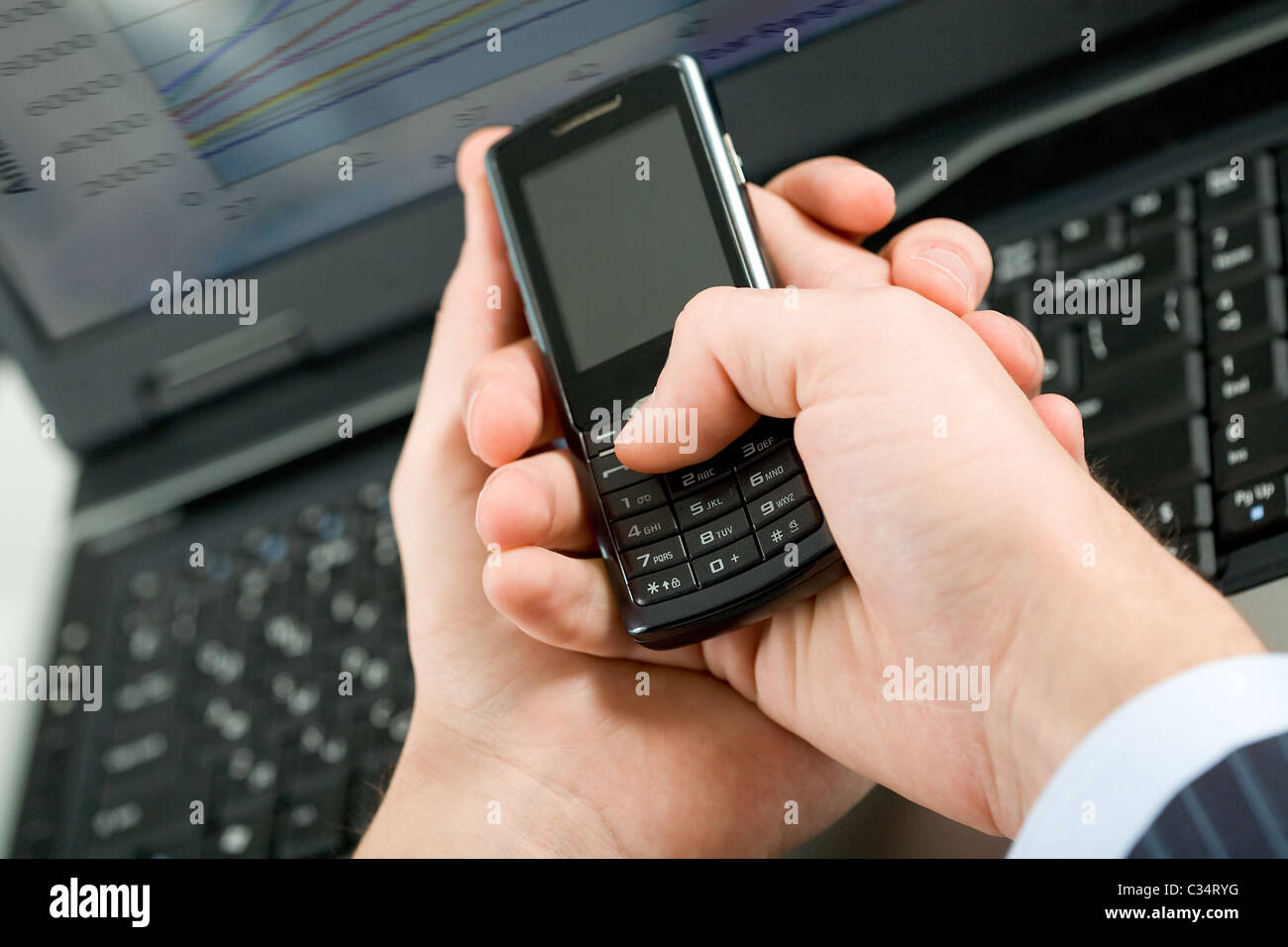 Photo of male hand holding cellular phone and pressing its buttons ...