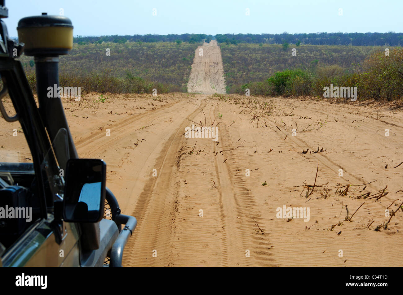 Dead straight sandy rough road through the Chobe Forest Reserve near ...