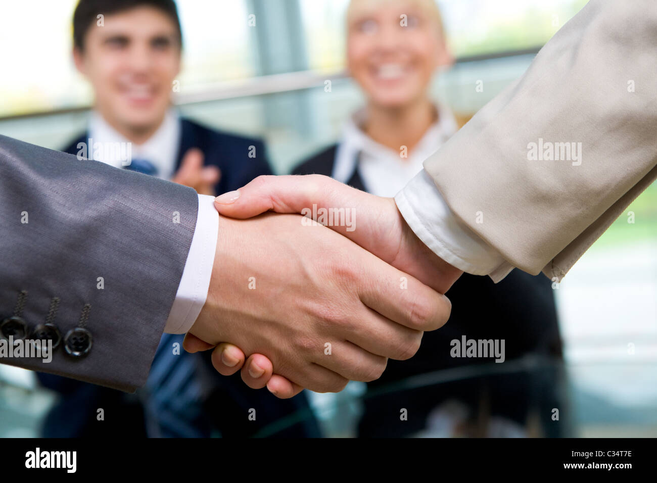 Photo of handshake of business partners on background of happy people ...