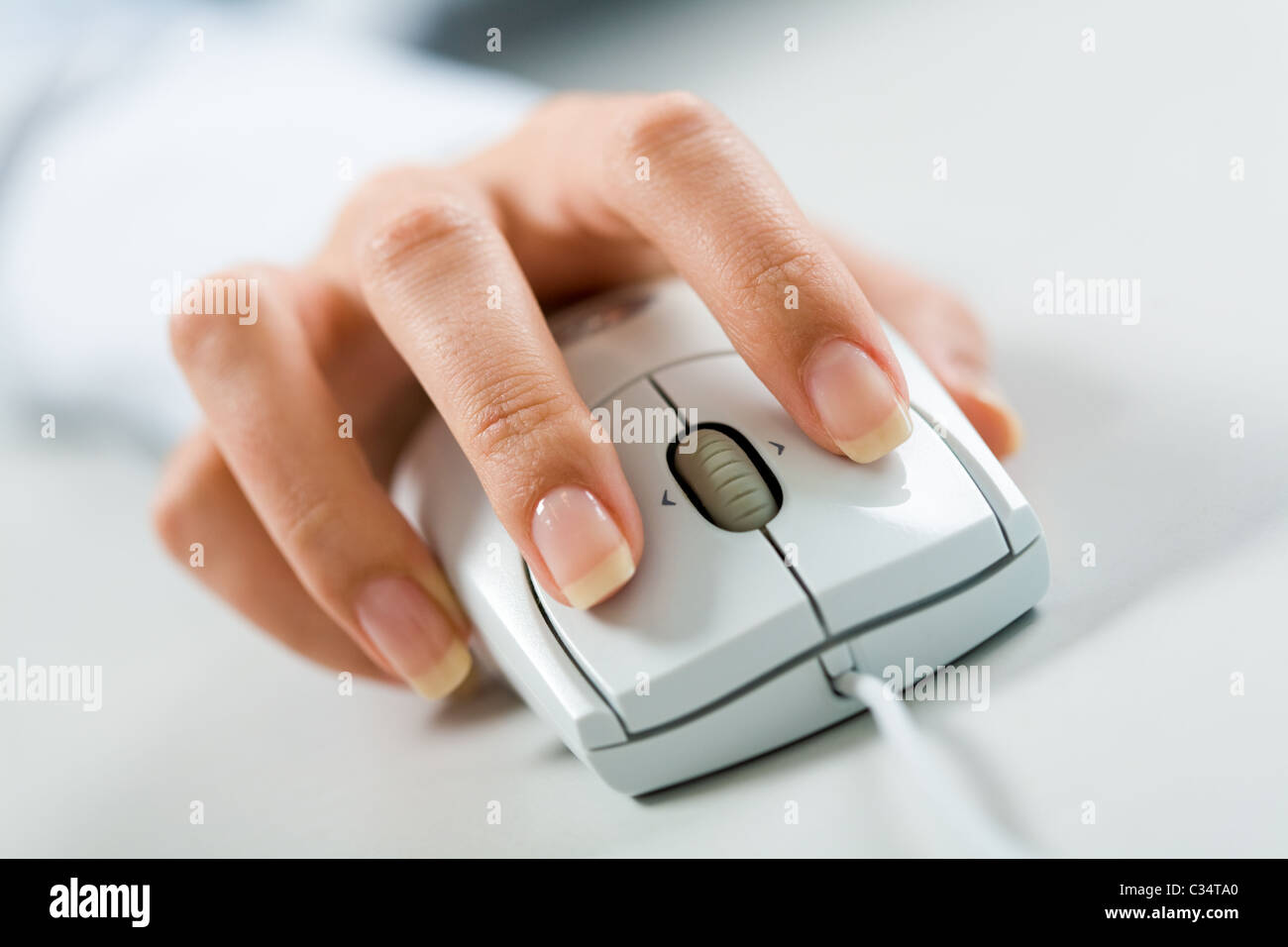 Close-up of female hand on white mouse Stock Photo - Alamy