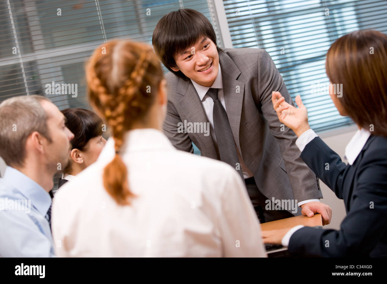 Photo of several employees discussing something with focus on their ...