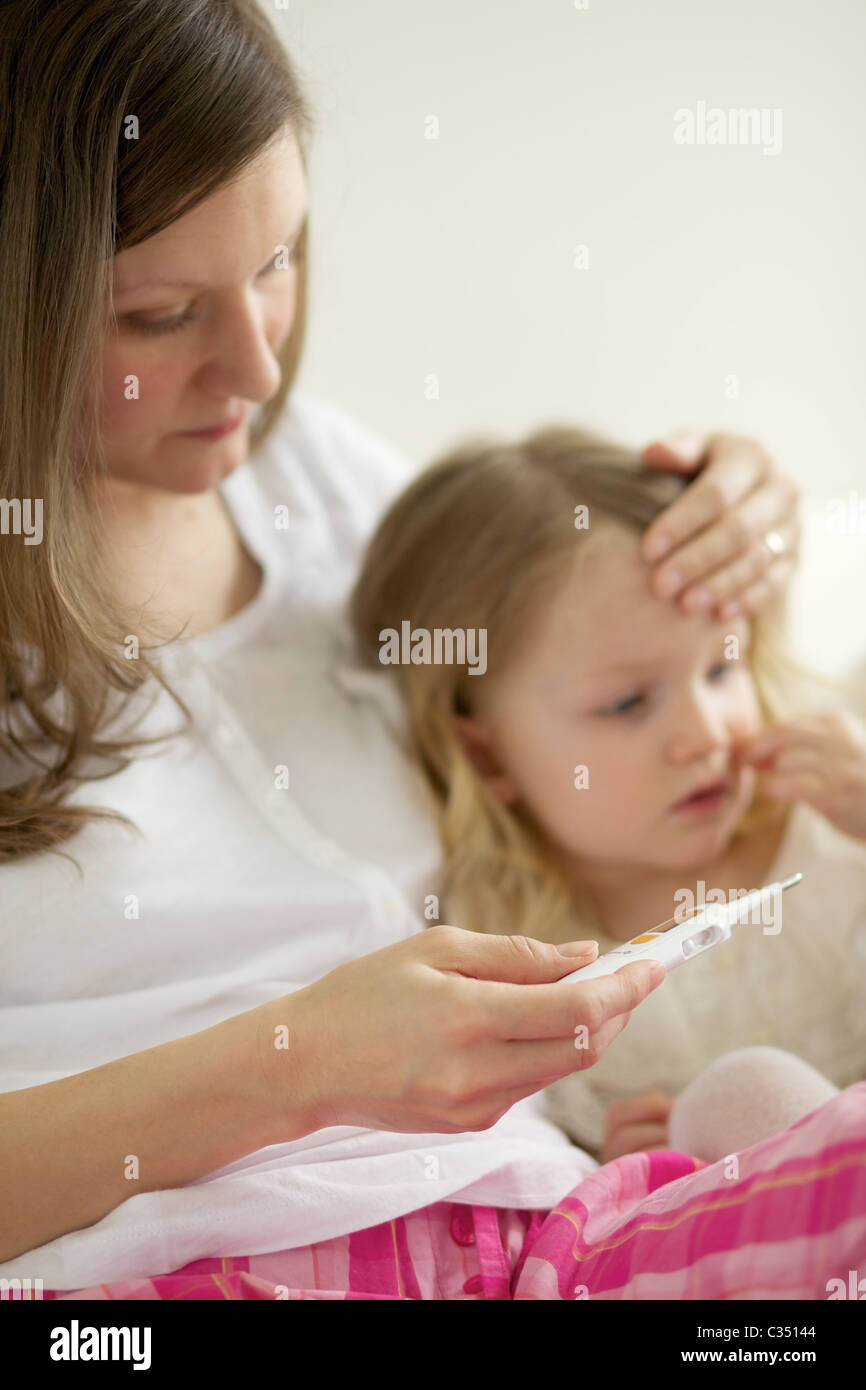 Mother checking her daughter's fever with digital thermometer Stock Photo - Alamy