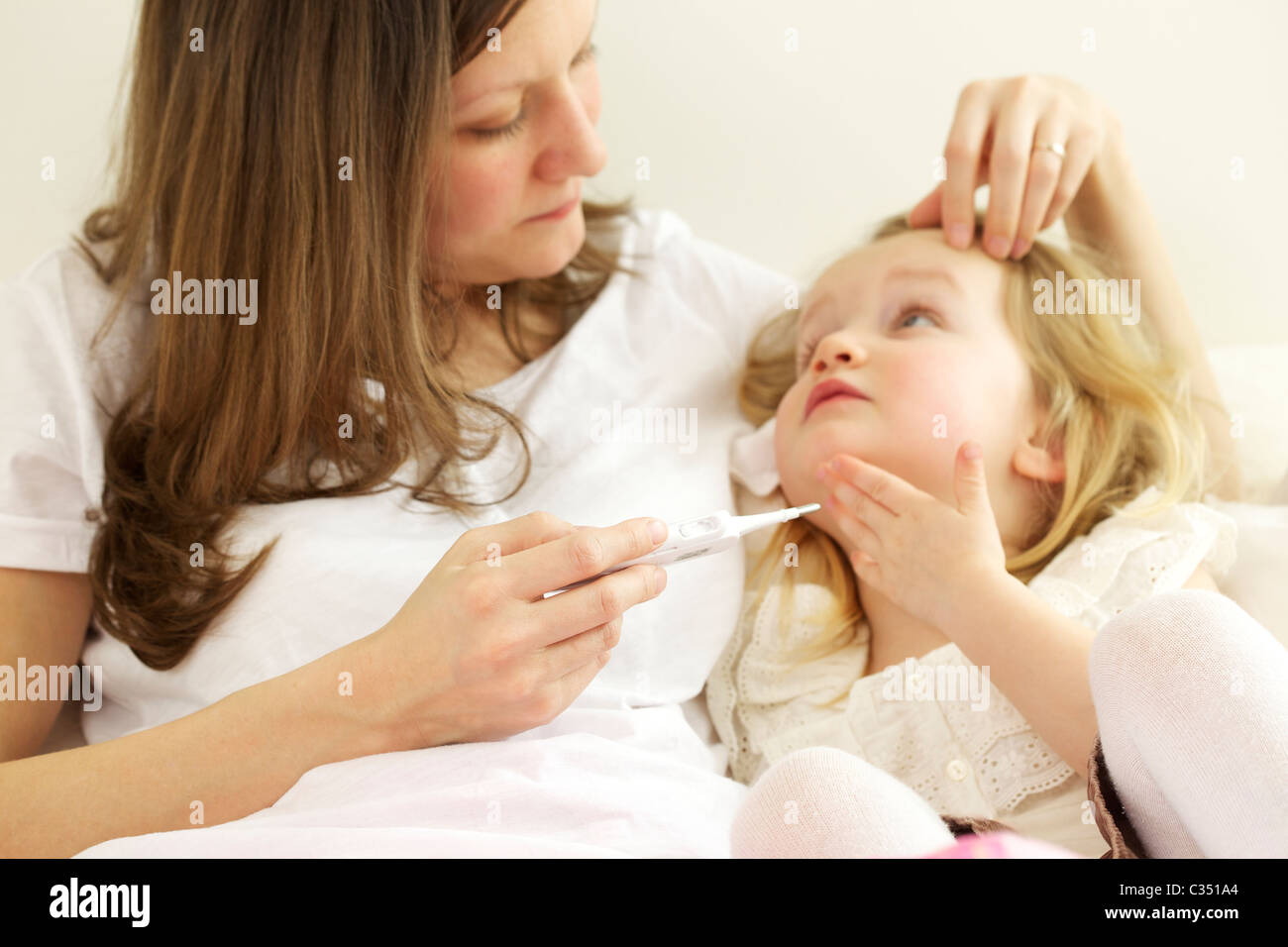 Mother checking her daughter's fever with digital thermometer Stock Photo - Alamy