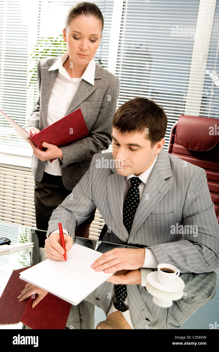 Portrait of serious boss going to sign contract while executive ...