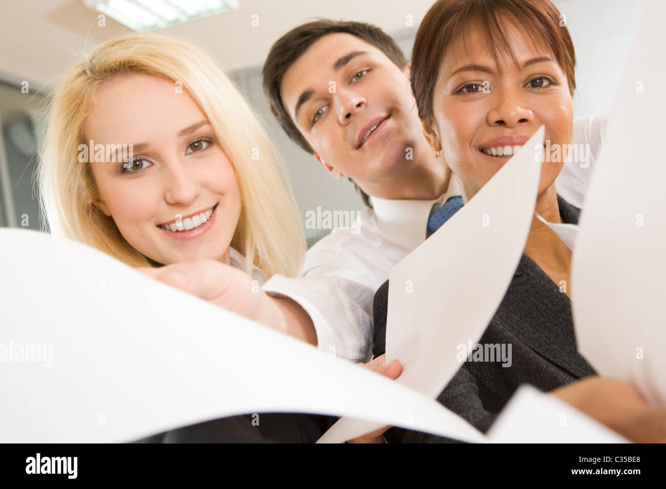 Front view of happy co-workers looking at camerea with smiles and ...