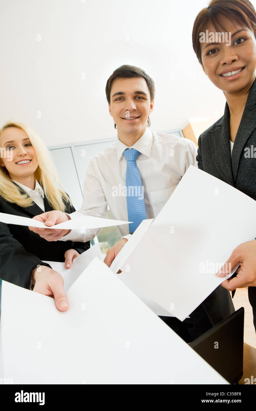 Image of friendly managers offering you application forms with smiles ...