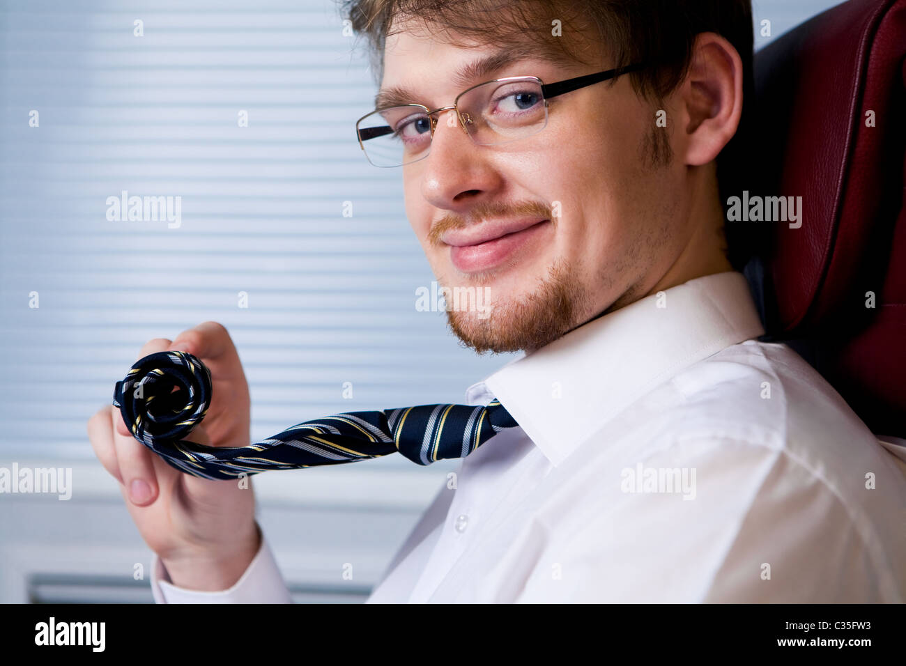 Smart ceo looking at camera with smile and holding his rolled tie Stock ...