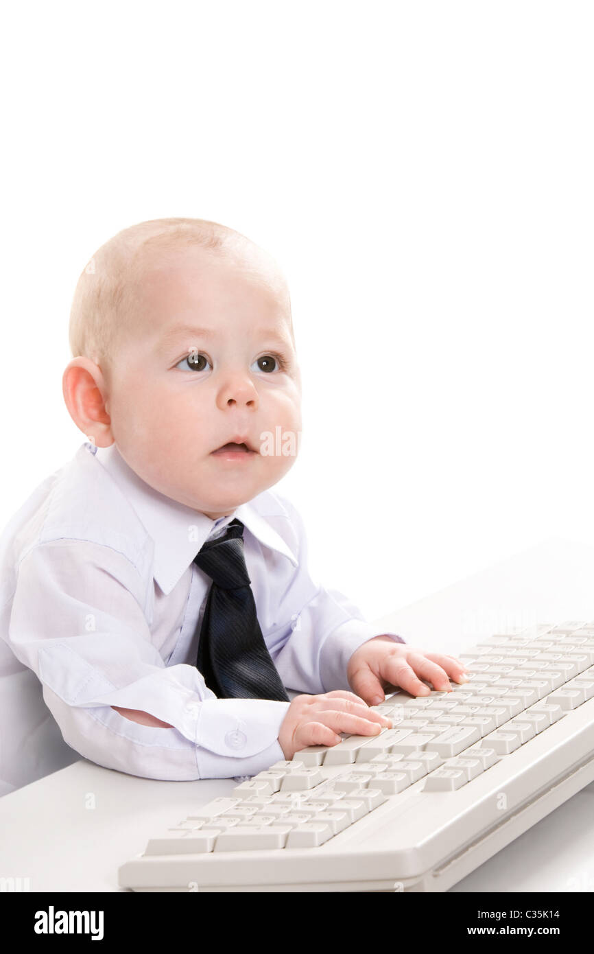 Portrait of serious baby boy typing on keyboard and looking aside Stock ...