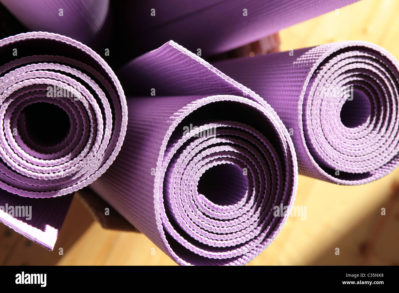 Purple athletic mats rolled and placed inside a basket shoot under ...