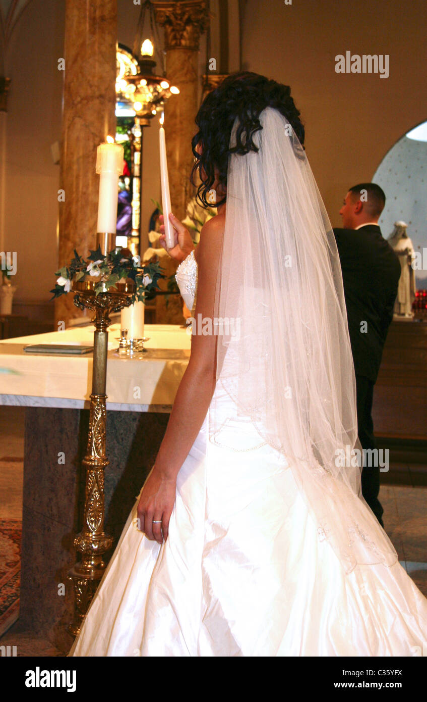 Bride lighting a candle during church wedding ceremony Stock Photo - Alamy