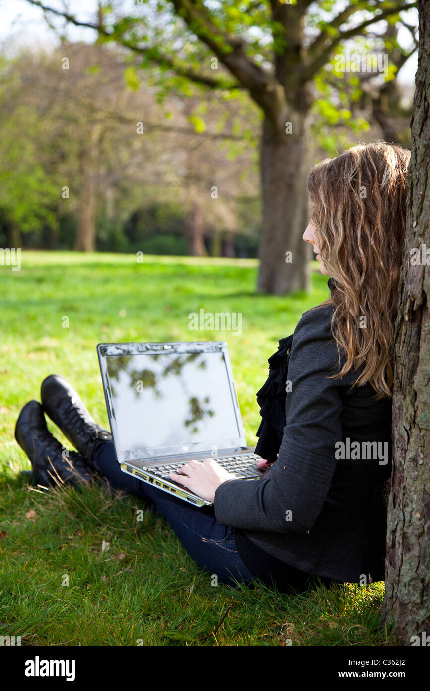 Woman sitting in Hyde Park London with a laptop Stock Photo - Alamy