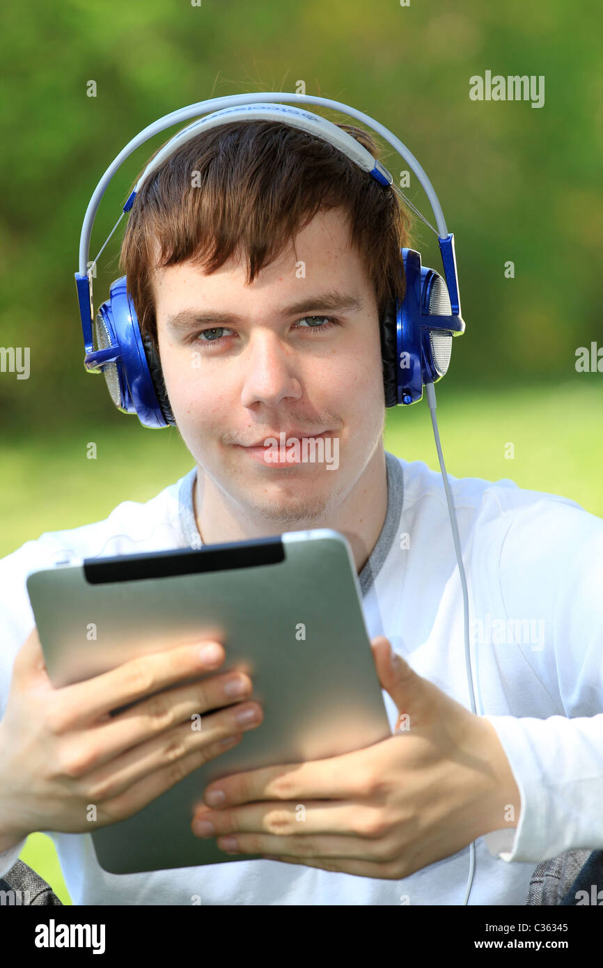 Happy young man holding an ipad Stock Photo - Alamy