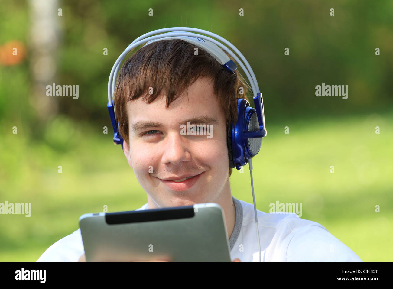 Happy young man holding an ipad Stock Photo - Alamy