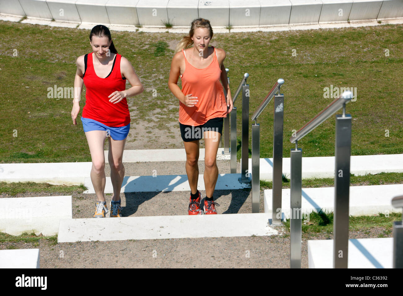 Two female hobby runner, jogging in a public park. Running up a ...
