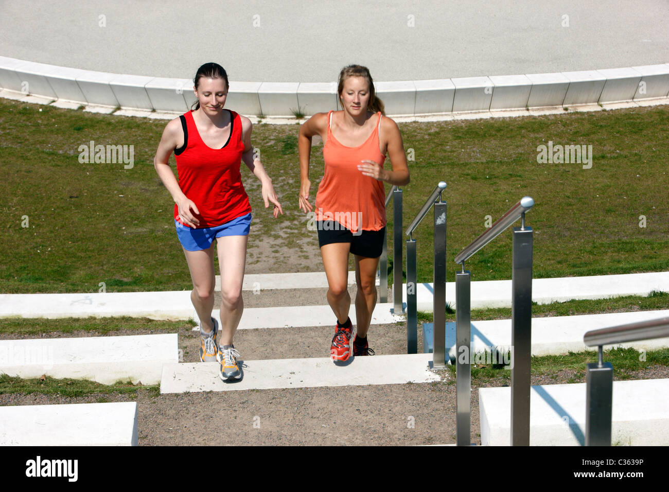 Two female hobby runner, jogging in a public park. Running up a ...