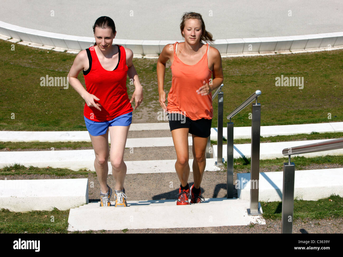 Two female hobby runner, jogging in a public park. Running up a ...